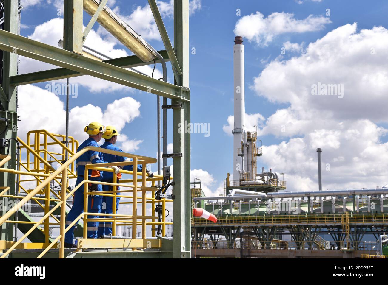chemical industry plant - workers in work clothes in a refinery with ...