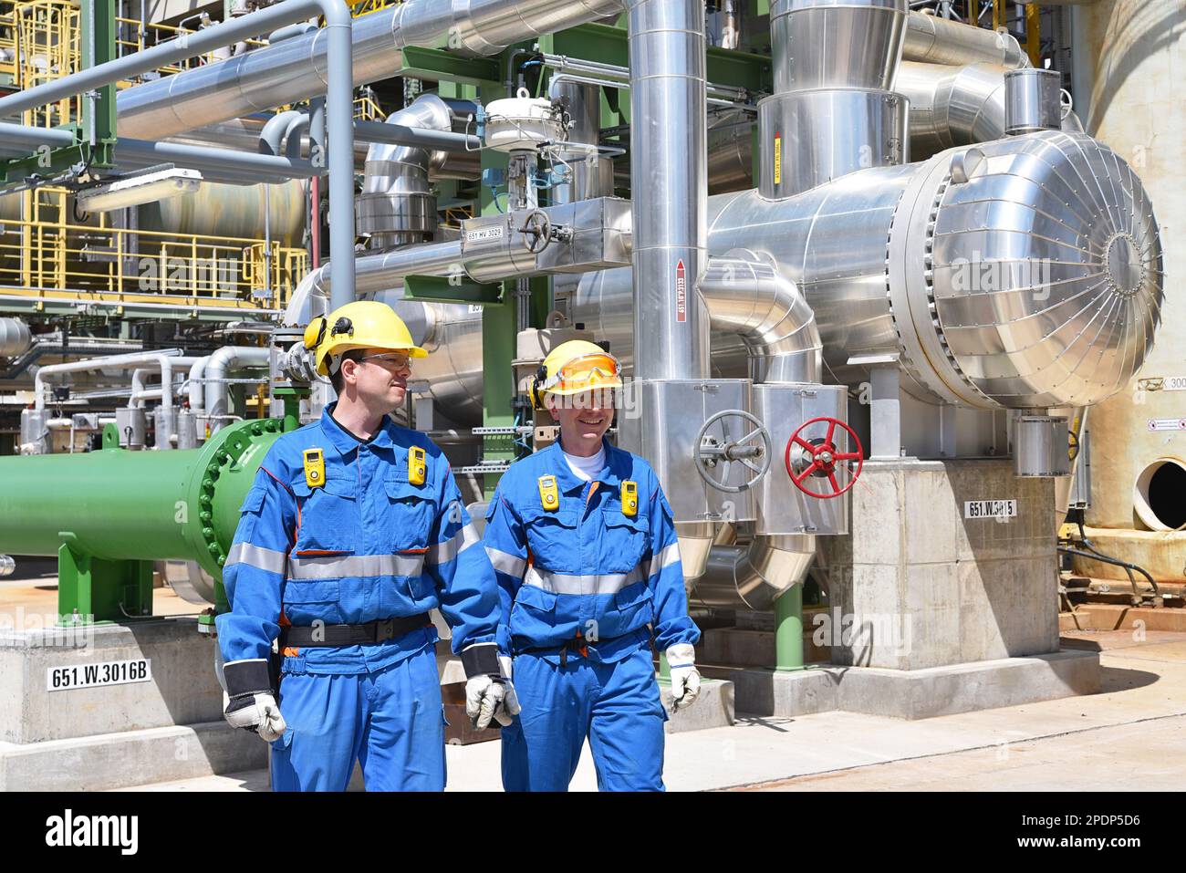 chemical industry plant - workers in work clothes in a refinery with ...