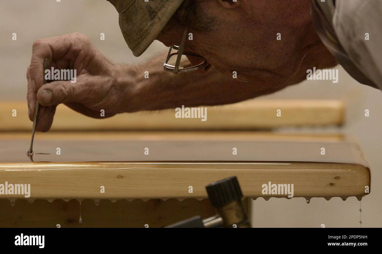 James "Tom Kitty" Mills pulls a speck of dust from the polymer coating ...