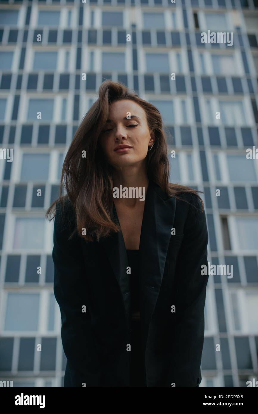 Fashion street style portrait of a beautiful girl in a black suit. A ...