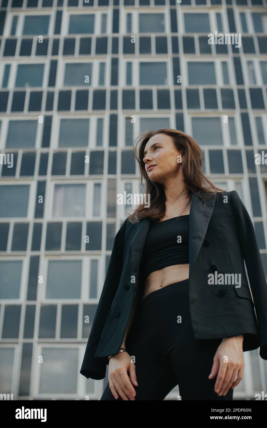 Fashion street style portrait of a beautiful girl in a black suit. A ...