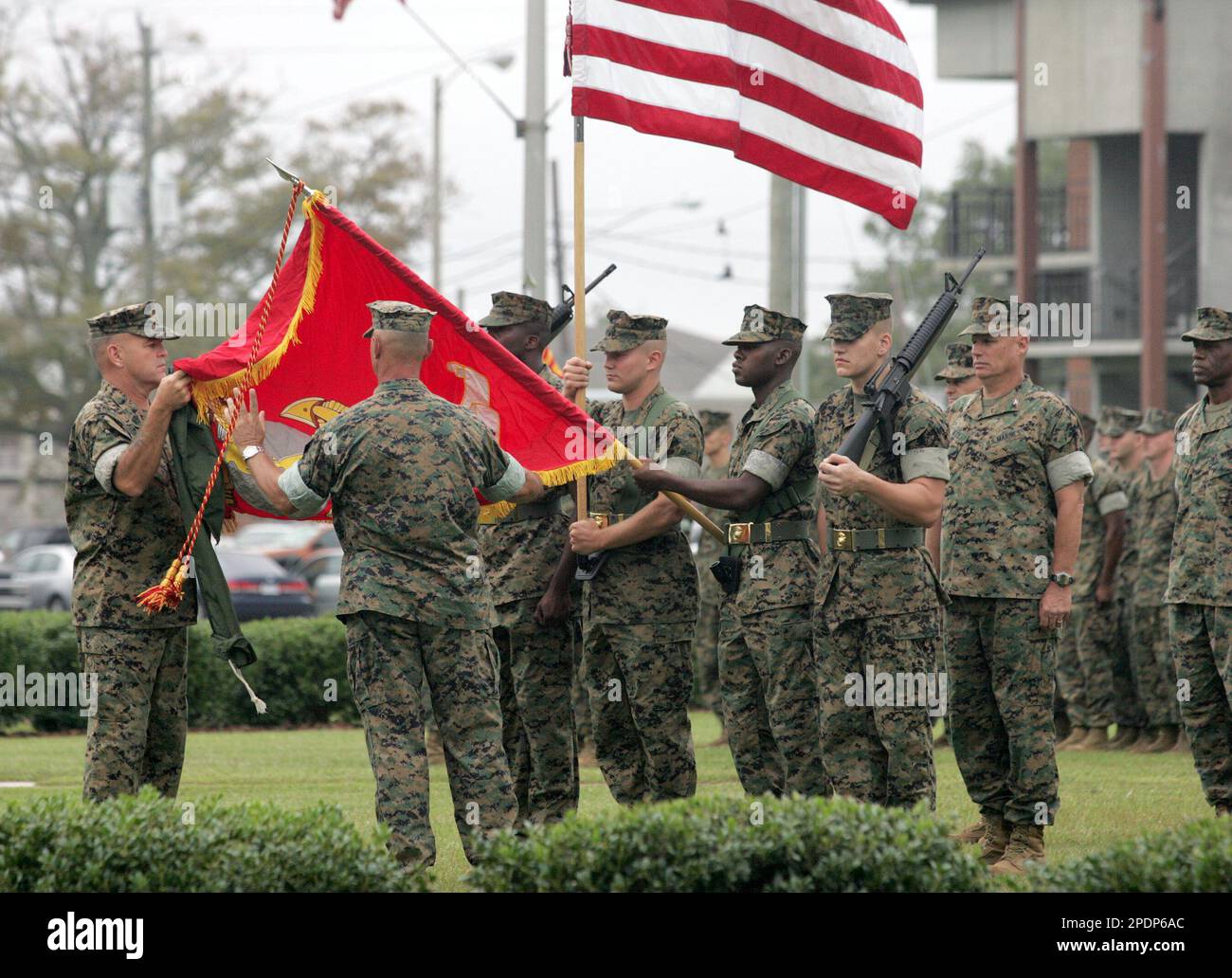 U.S. Marine Sgt. Maj. Charles Tucker, left, unfurls the Marine flag ...