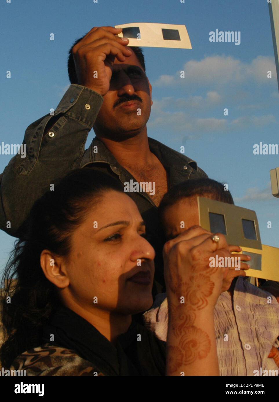 A Pakistani family look at partial solar eclipse in Karachi, Pakistan ...
