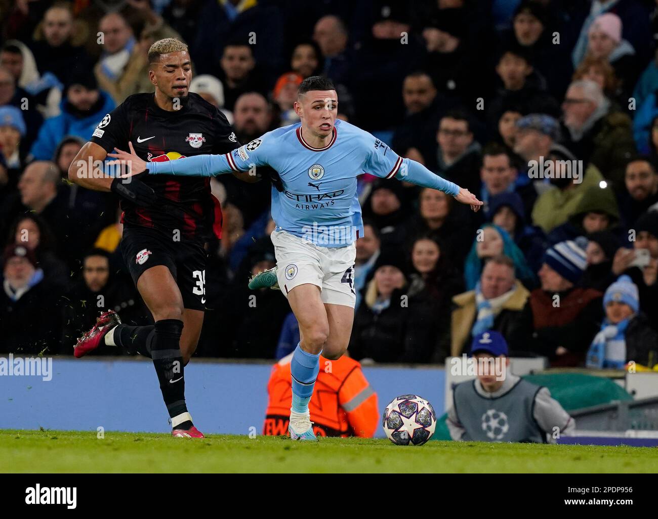 Manchester, UK. 14th Mar, 2023. Phil Foden of Manchester City (R) is challenged by Benjamin ...