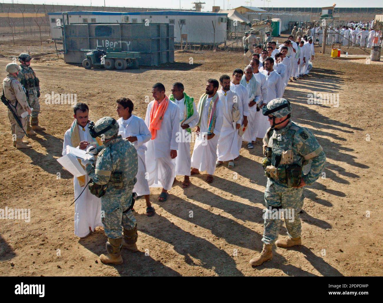 Detainees are checked by U.S. soldiers during a prisoner release at Abu ...