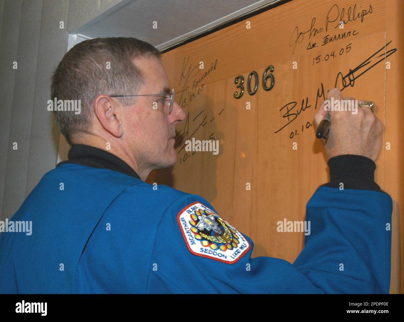 Astronaut William McArthur of the U.S. leaves his signature on the door ...