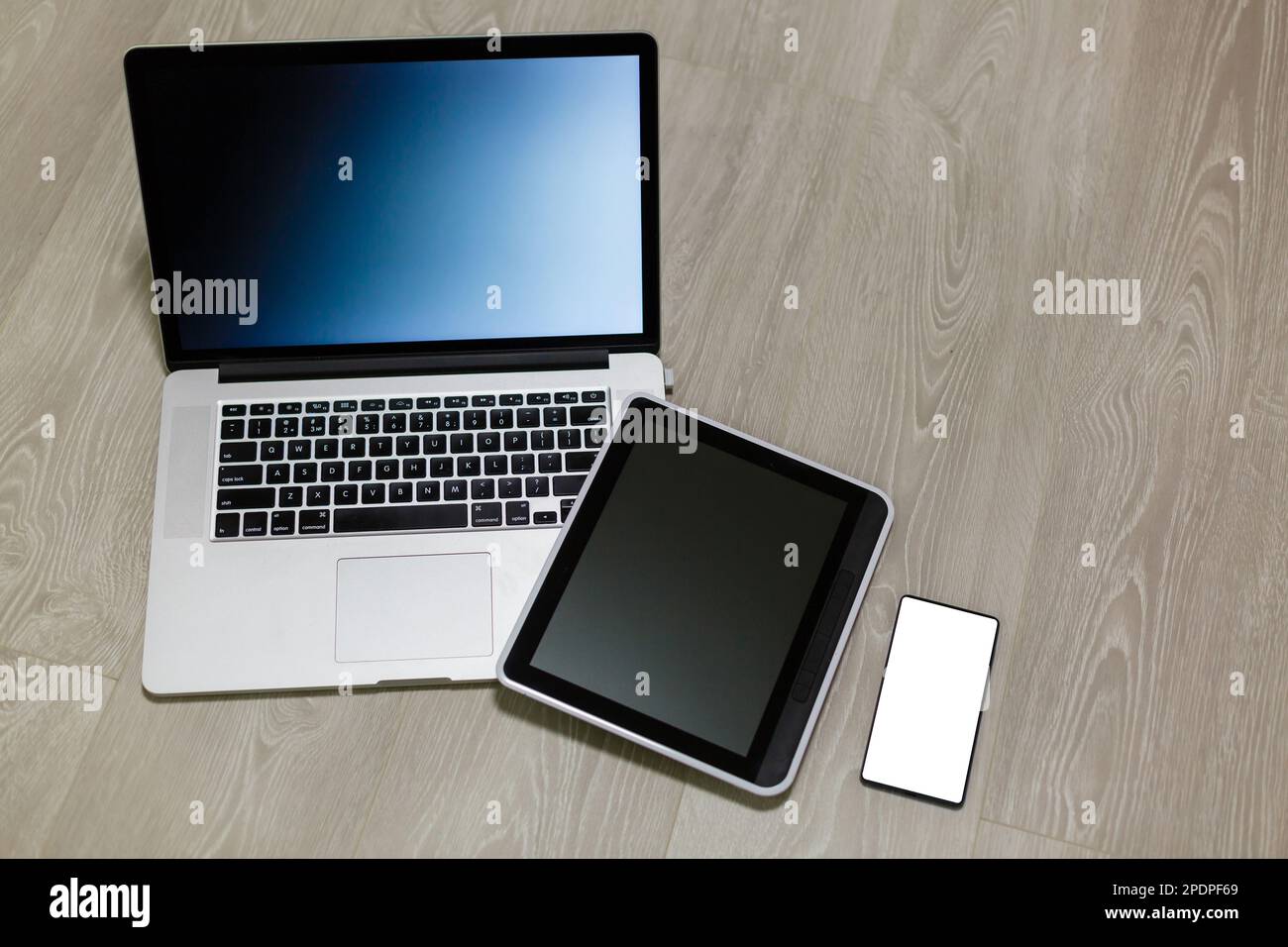 Modern laptop, mobile phone, tablet, and notebook on white wooden ...