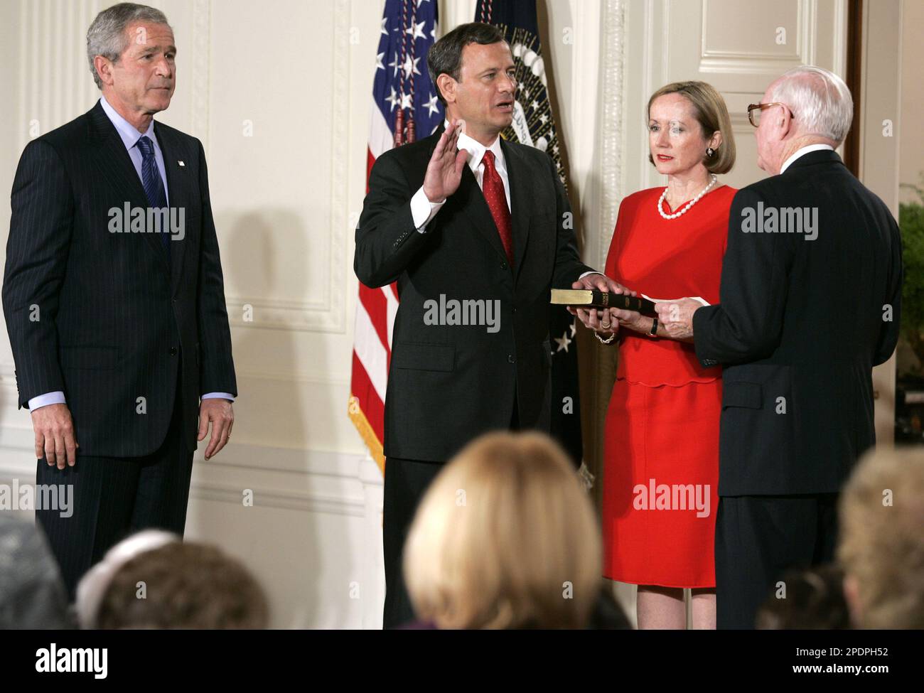 President Bush watches as Judge John Roberts is sworn in by Supreme ...