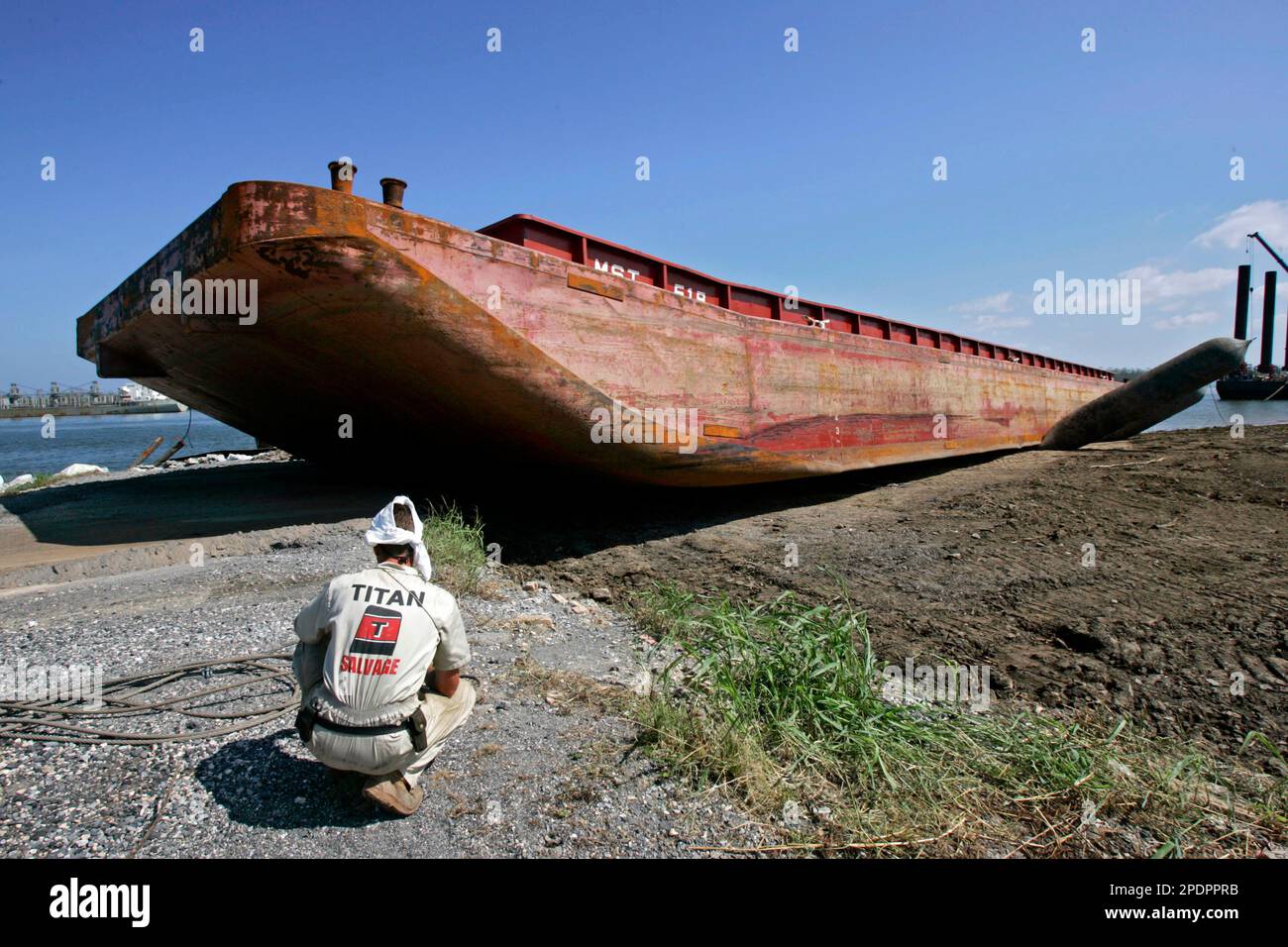Chris Taylor with Titan Salvage monitors as a tug boat pulls a barge ...