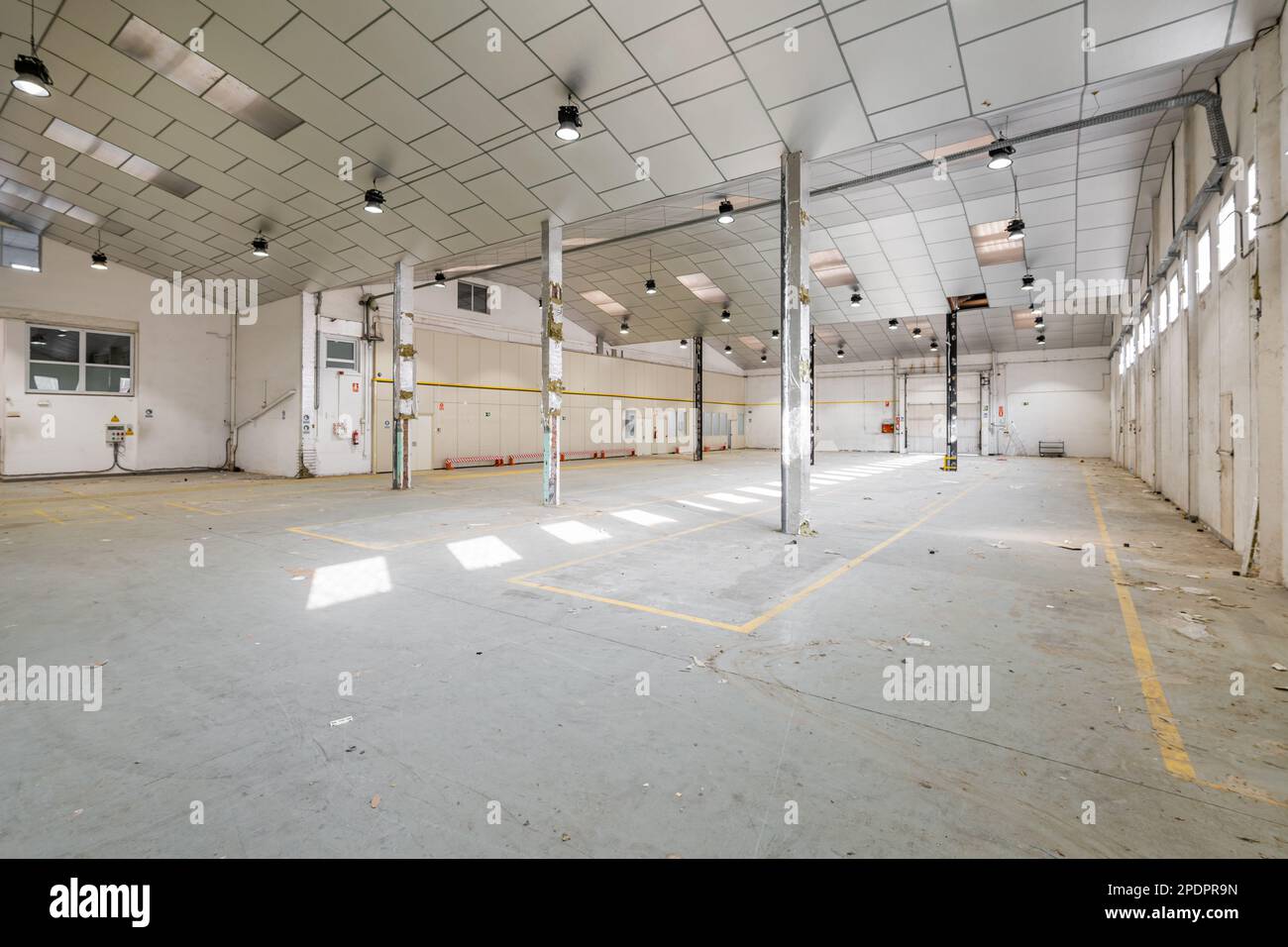 Parking garage with lights, light-colored walls, metal beams and ...