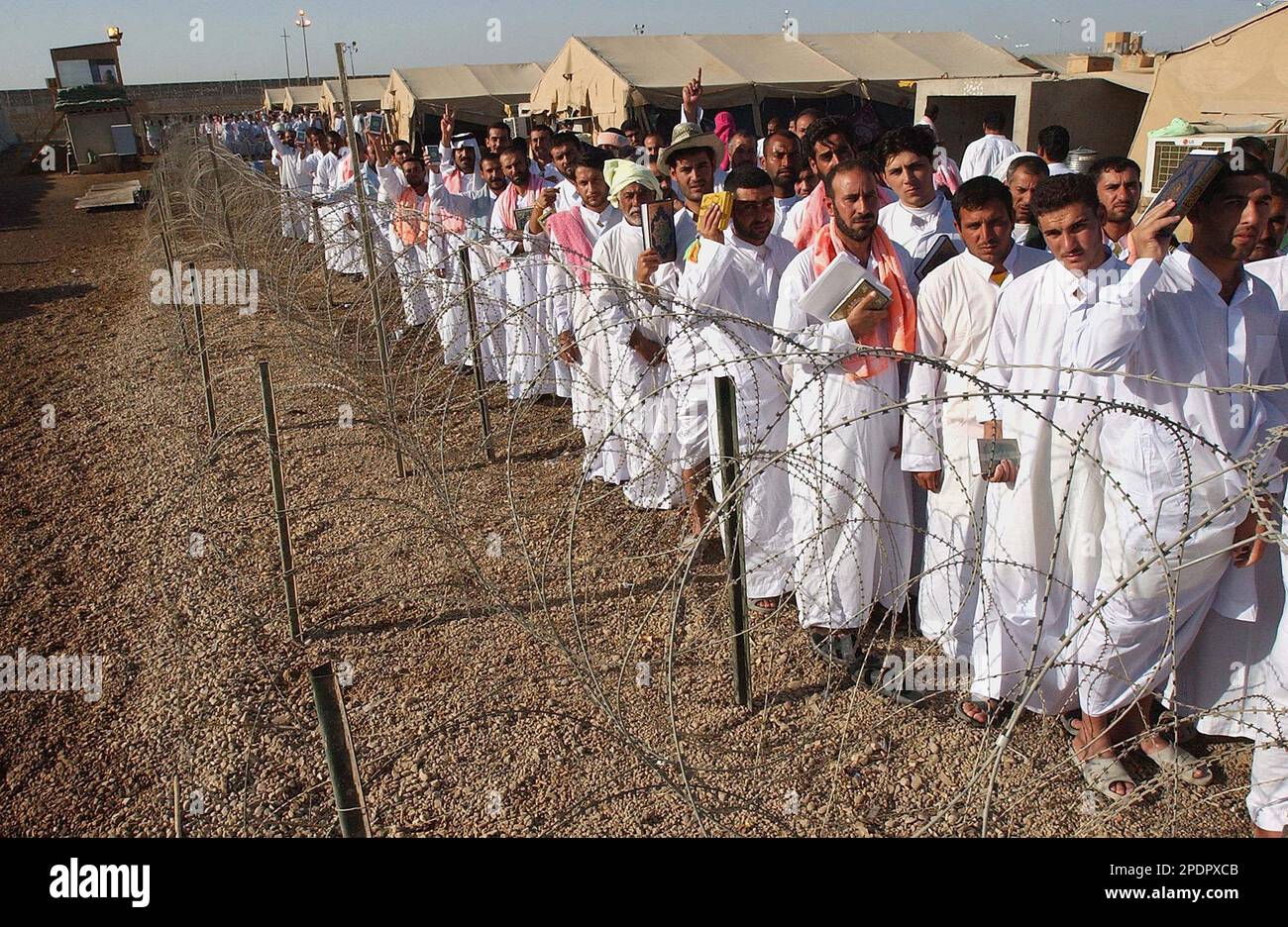 Iraqi detainees stand in line to be processed for release from Abu ...
