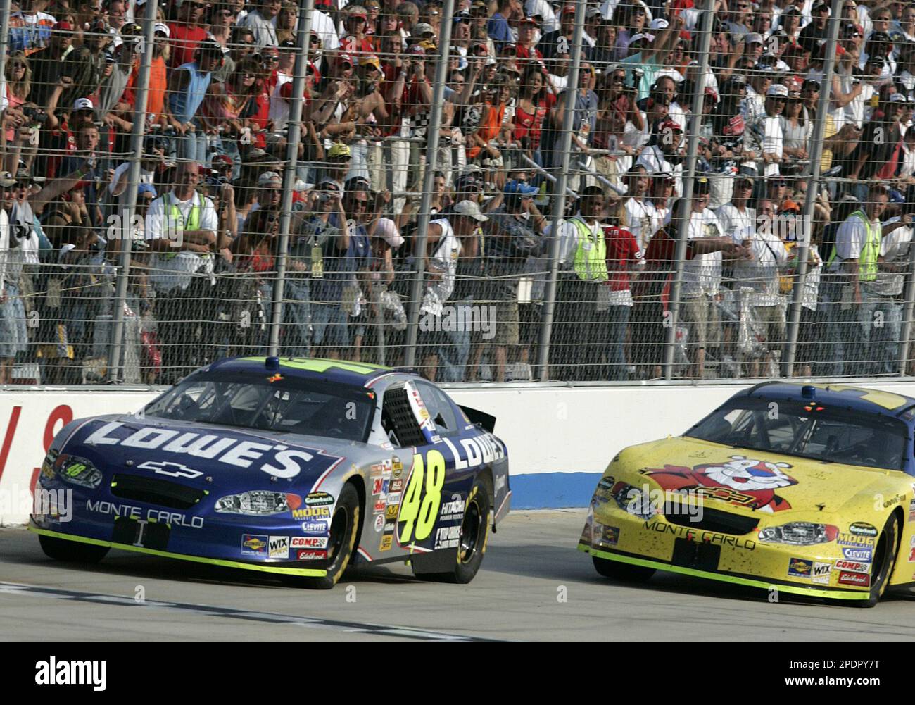 NASCAR racer Jimmie Johnson, left, edges out racer Kyle Busch, right ...
