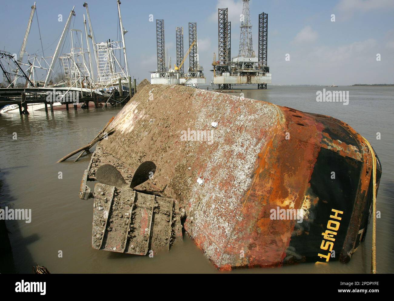 A commercial fishing boat is shown capsized with offshore oil drilling ...