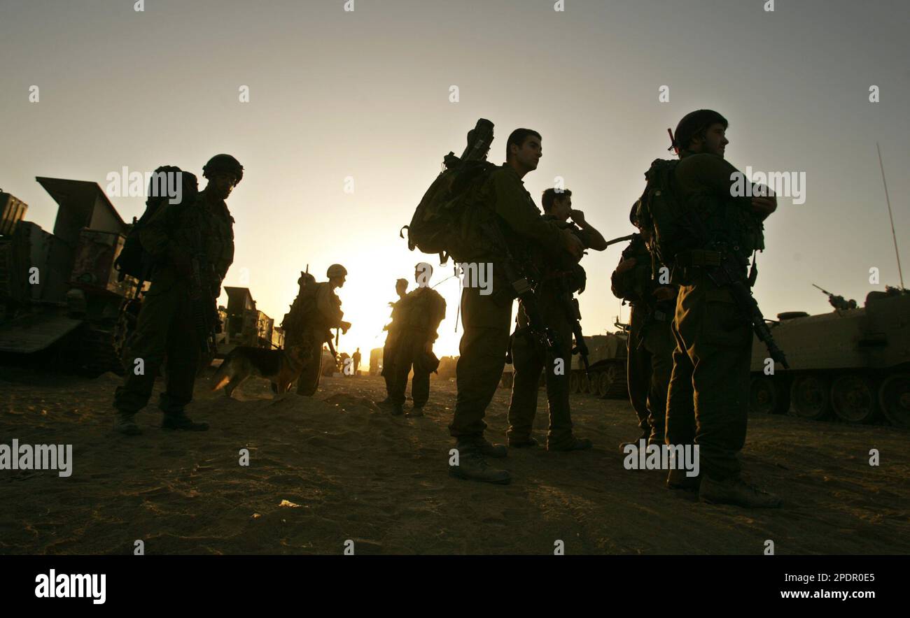 Israeli soldiers stand next to armored personnel carriers during a ...