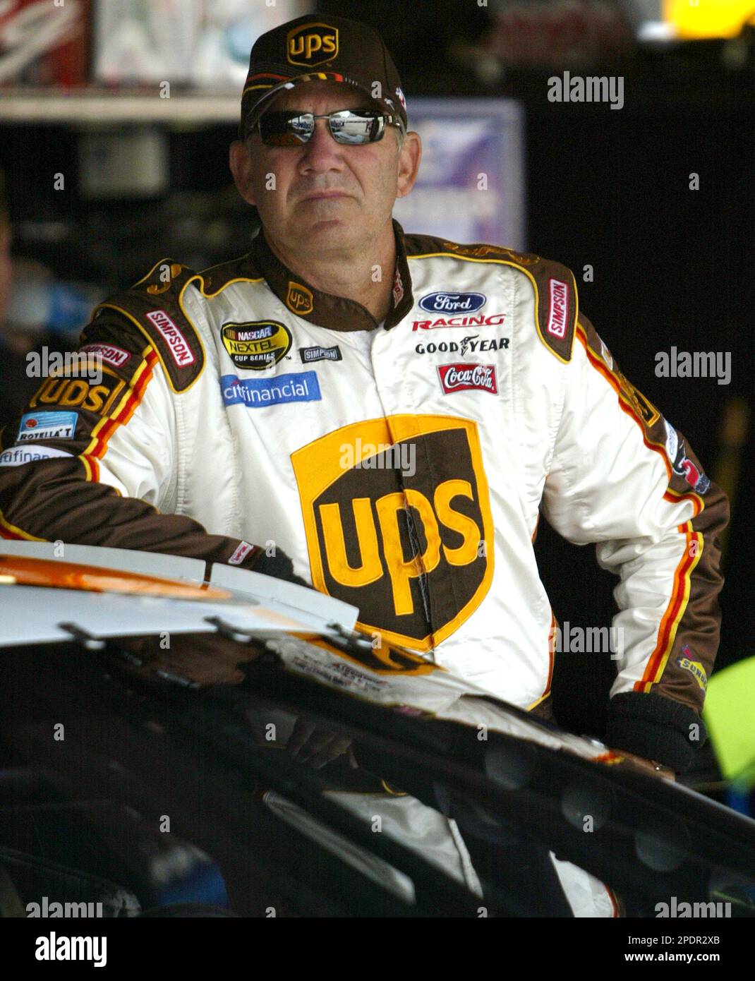 NASCAR driver Dale Jarrett stands with his race car in the garage area ...