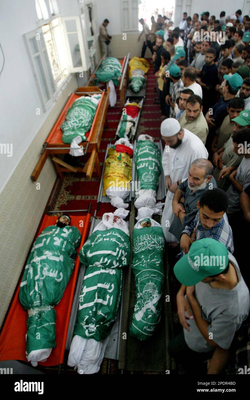Mourners pray over the bodies of nine Palestinians during their funeral ...