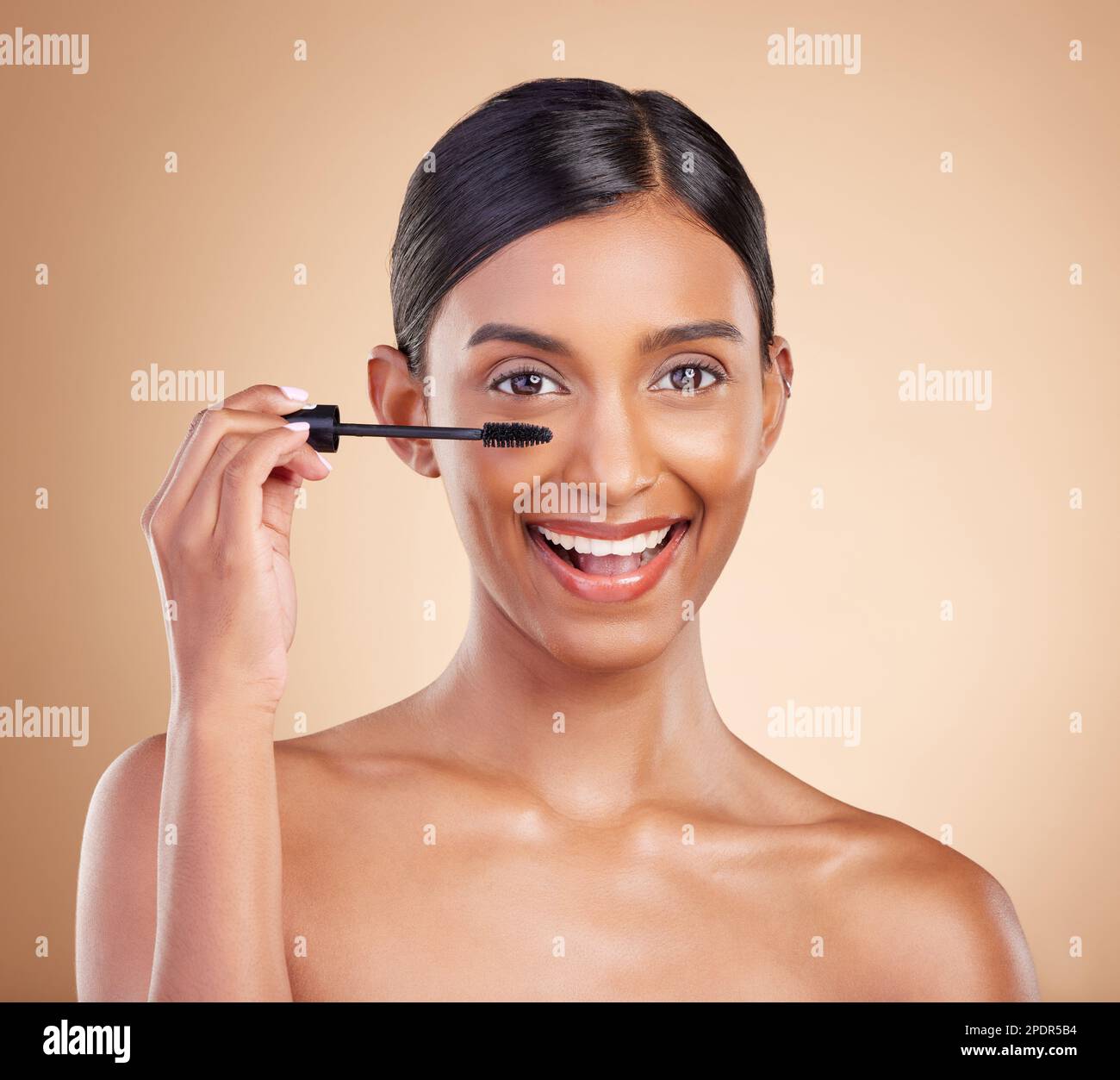 Portrait, beauty and mascara with a model woman in studio on a beige ...
