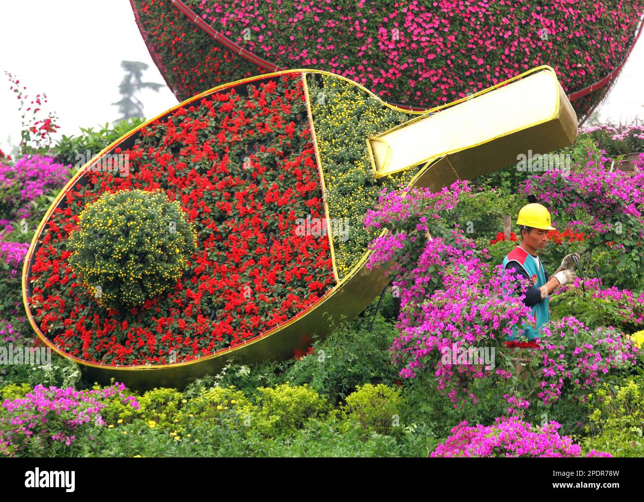 A worker prepares a flower arrangement in the shape of a table tennis ...