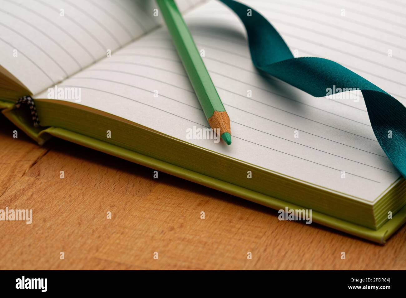 A lined notebook with a green pencil. Ready to take notes, sketch ideas ...