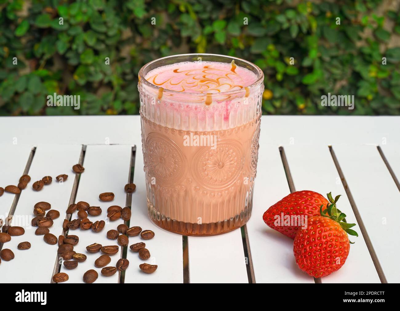 Strawberry latte with fresh strawberry and coffee beans on white wooden ...