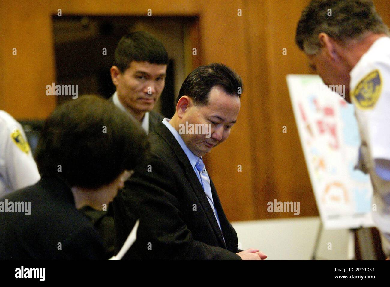 Nam The Tham, center right, and Siny Van Tran, behind left, enter a ...