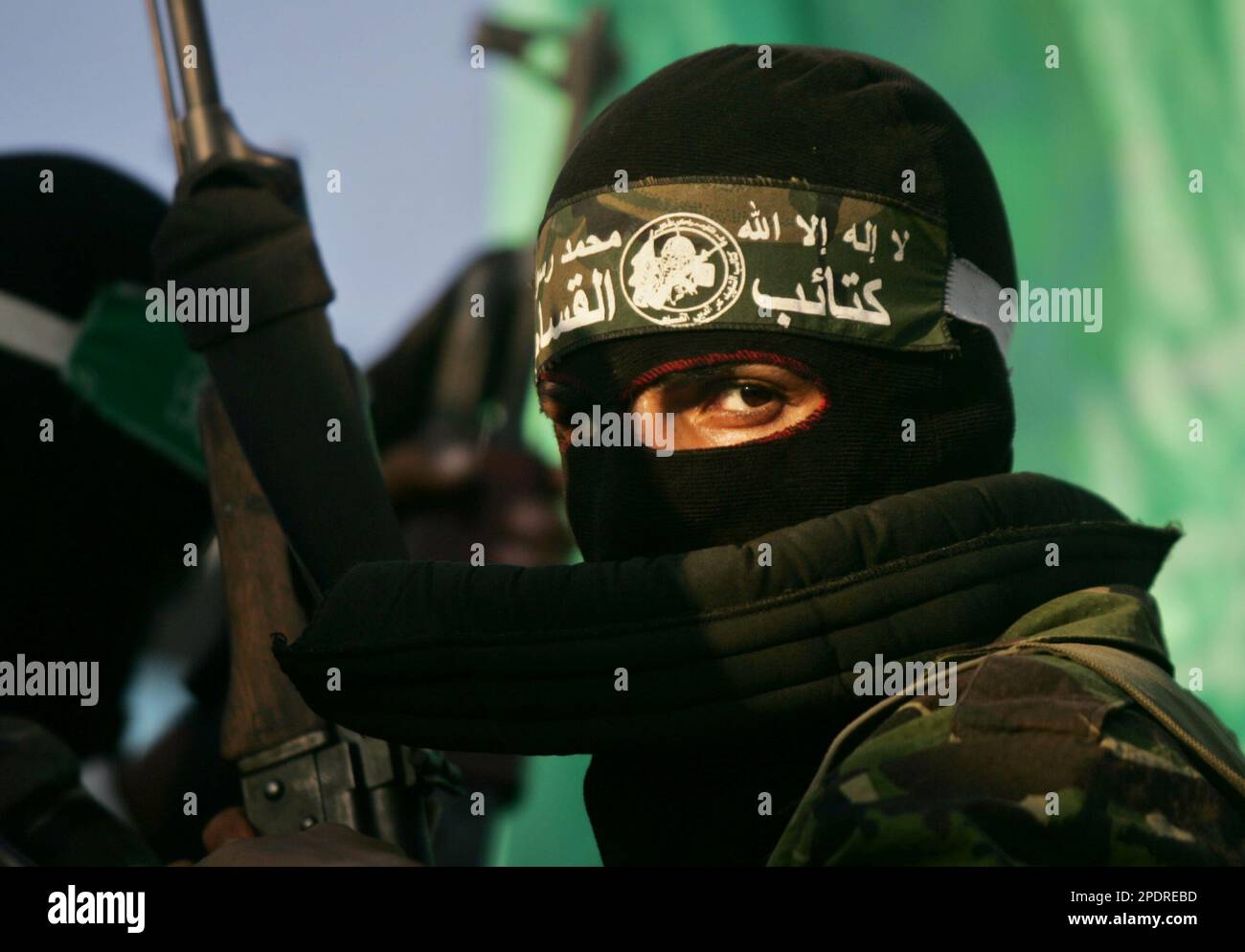 A masked Palestinian Hamas militant participates in a rally celebrating ...