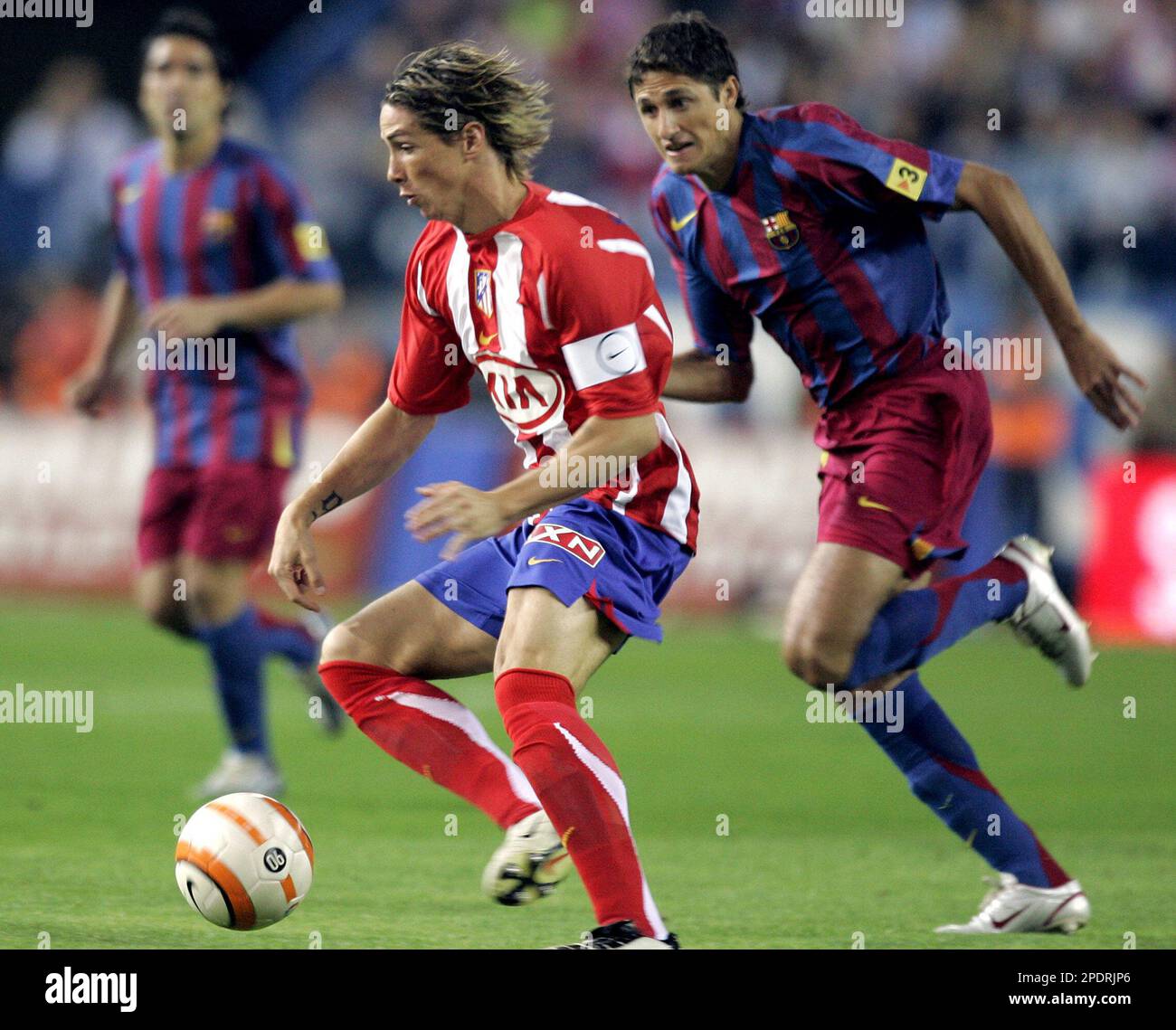 Atletico de Madrid's Fernando Torres, left steers the ball away from ...
