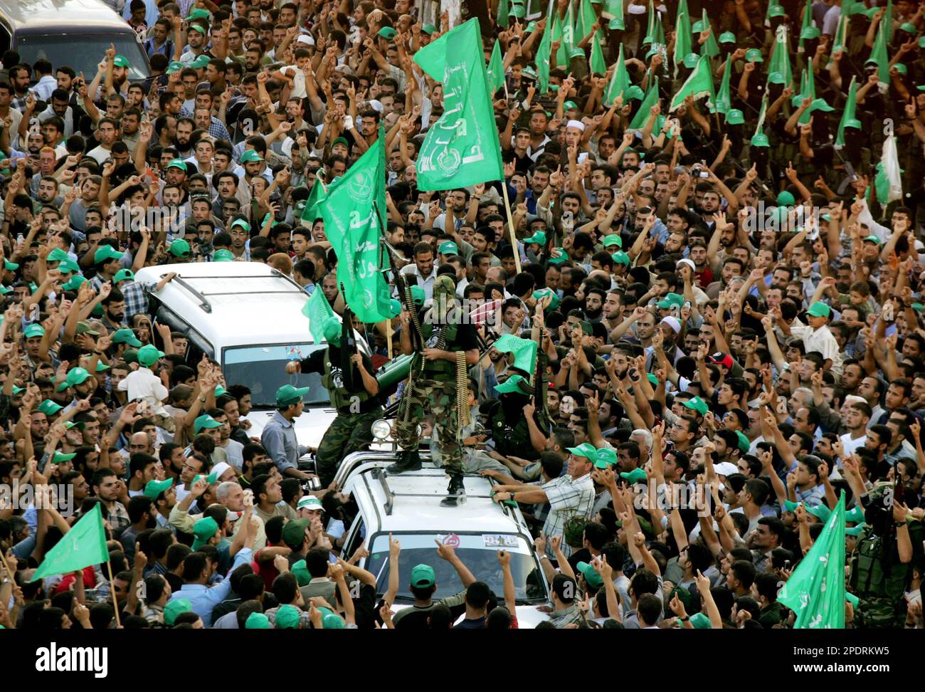 Palestinian supporters and militants of Hamas, raise their hands during ...