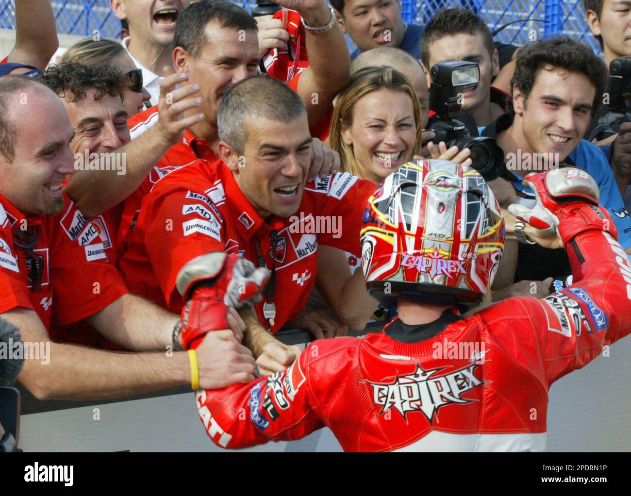The winner of MotoGP race Loris Capirossi of Italy, foreground, meets ...