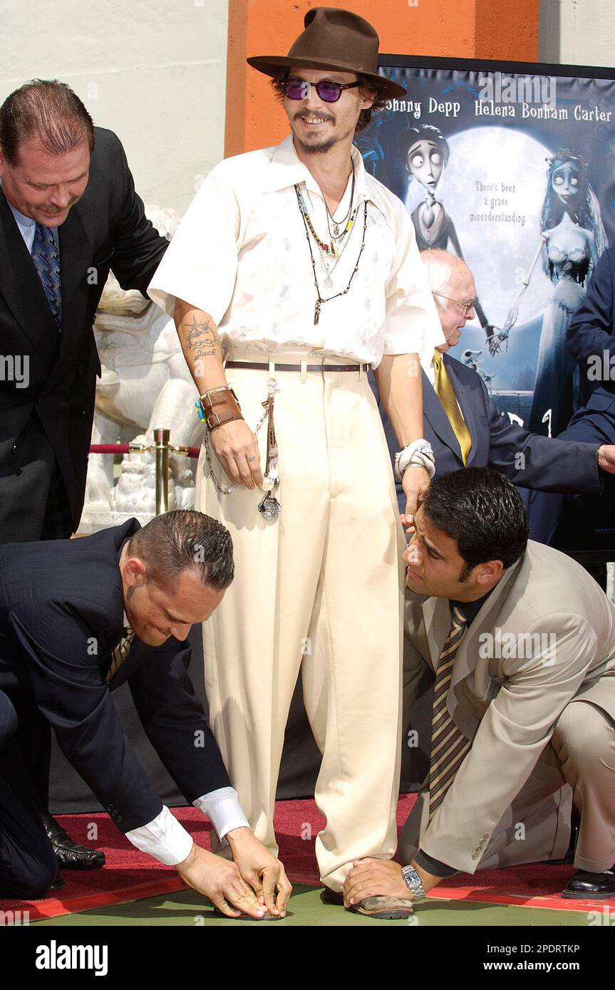 Actor Johnny Depp smiles as he gets his feet in the cement in the ...