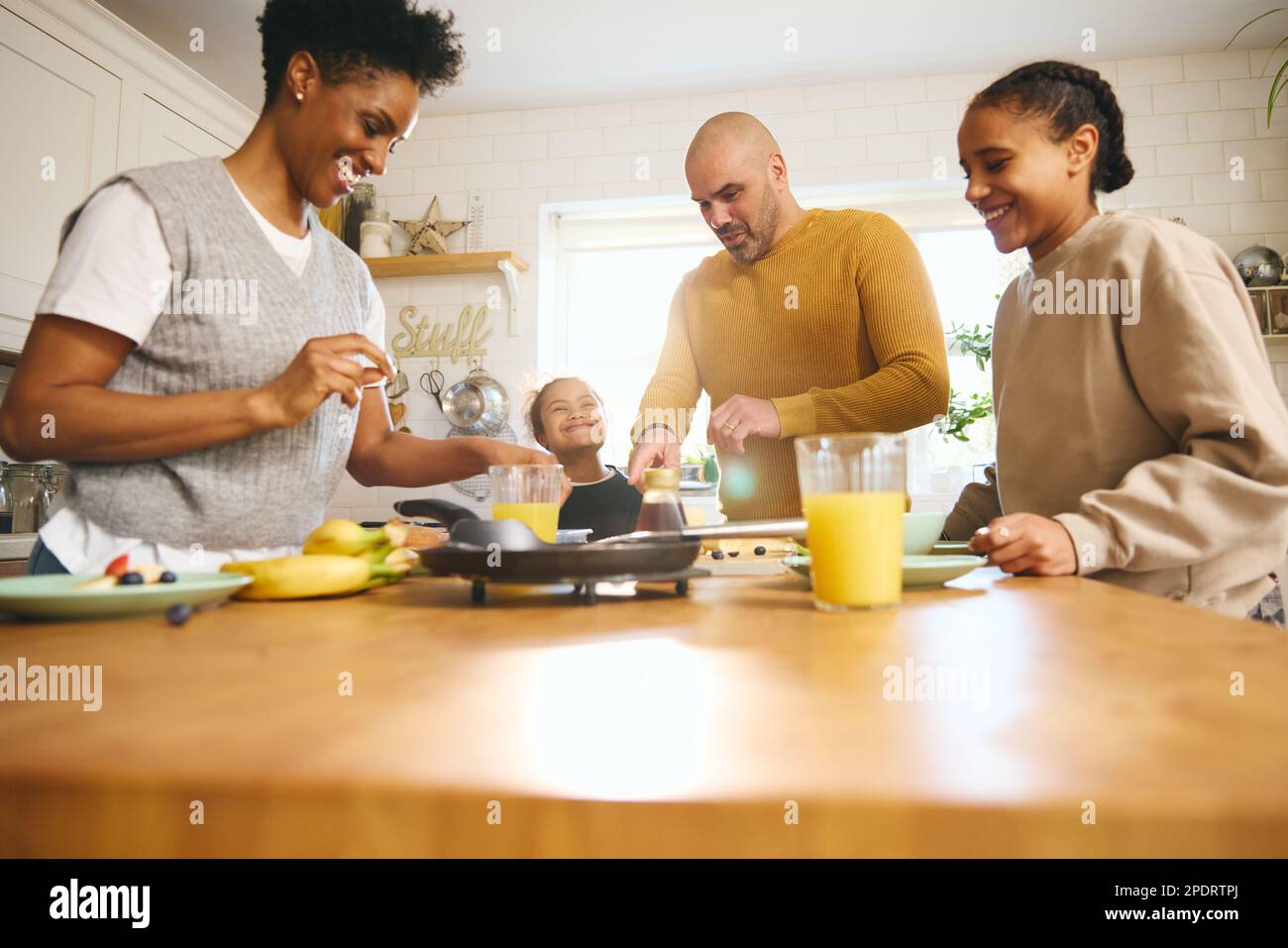 Family and boy with Down syndrome making pancakes for breakfast Stock ...