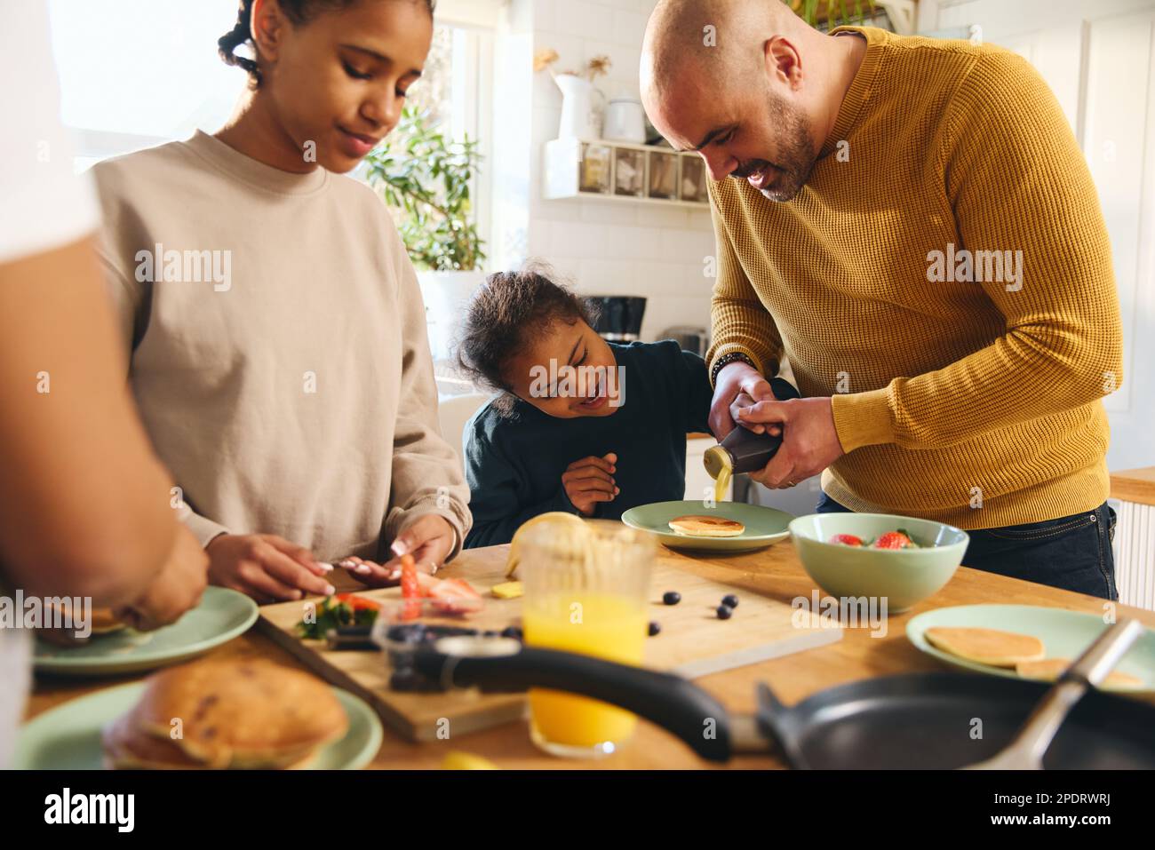 Boy with Down syndrome having pancakes for breakfast with family Stock ...