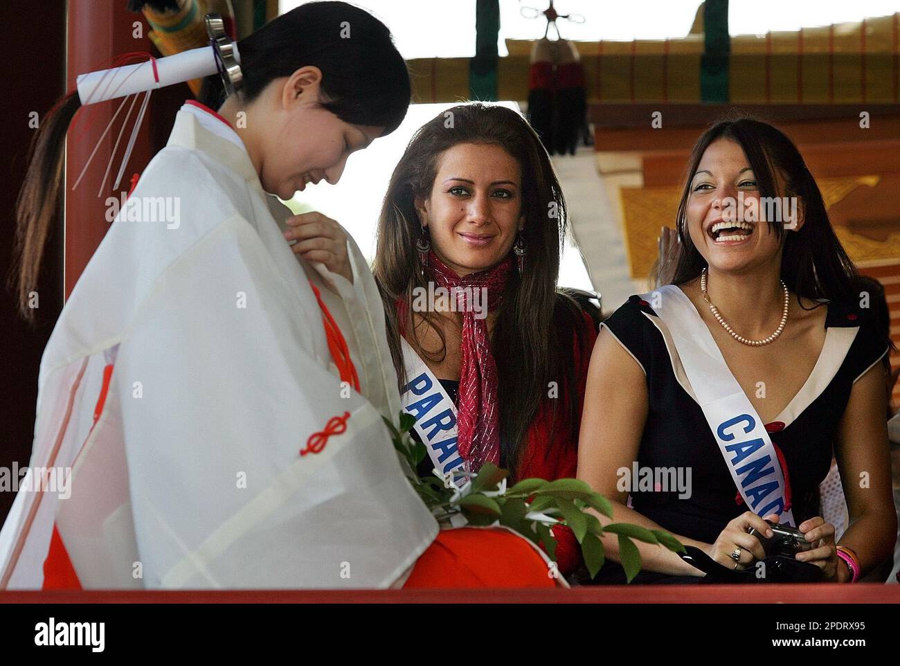 A Shito shrine maiden looks abashed as Miss Canada Micaela Smith, right ...