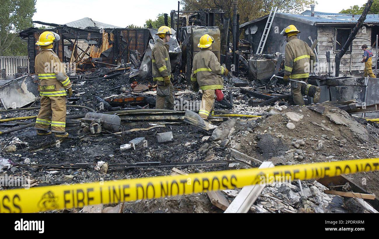 Livingston firefighters sift through the ruins of a house fire Thursday ...