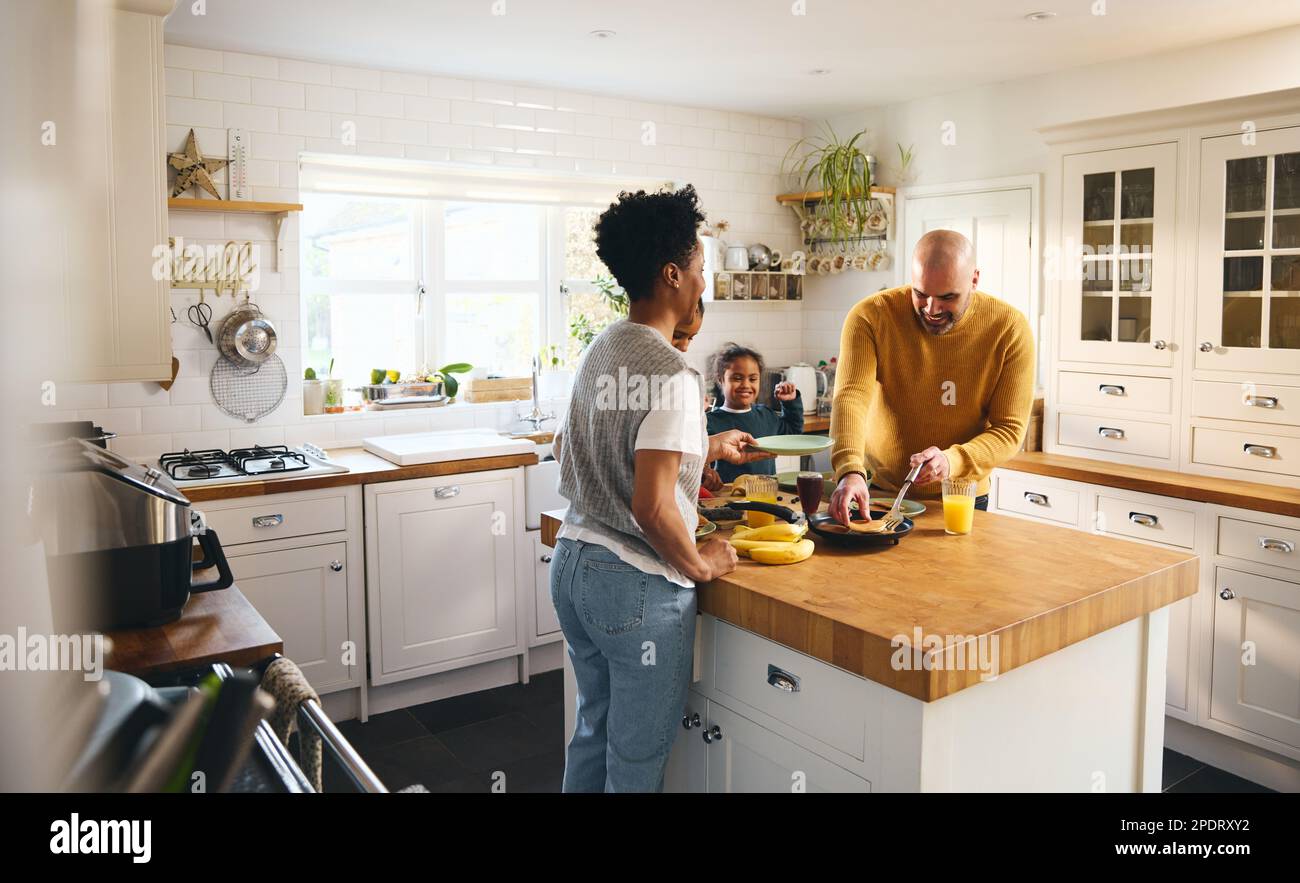 Boy with Down syndrome making pancakes for breakfast with parents Stock ...