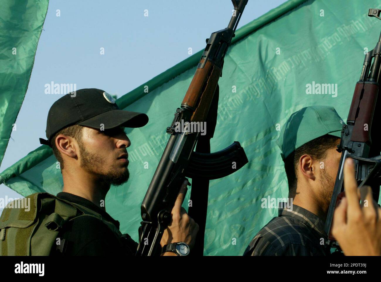 Palestinian militants from Hamas carry thier weapons during a rally ...