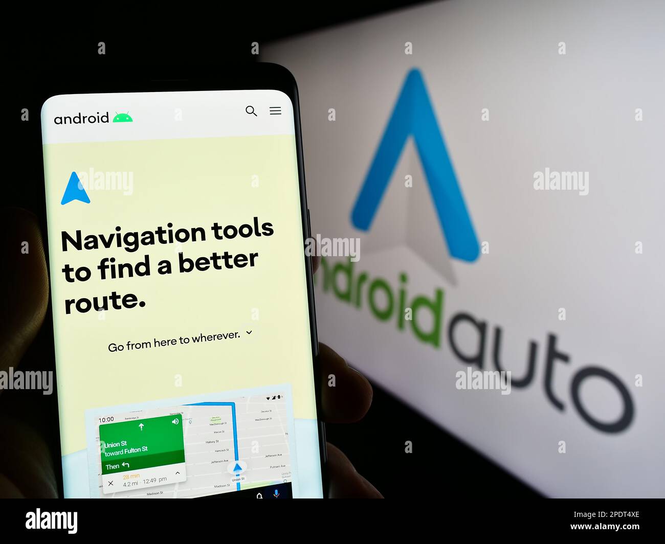 Person holding smartphone with webpage of mobile app Android Auto ...