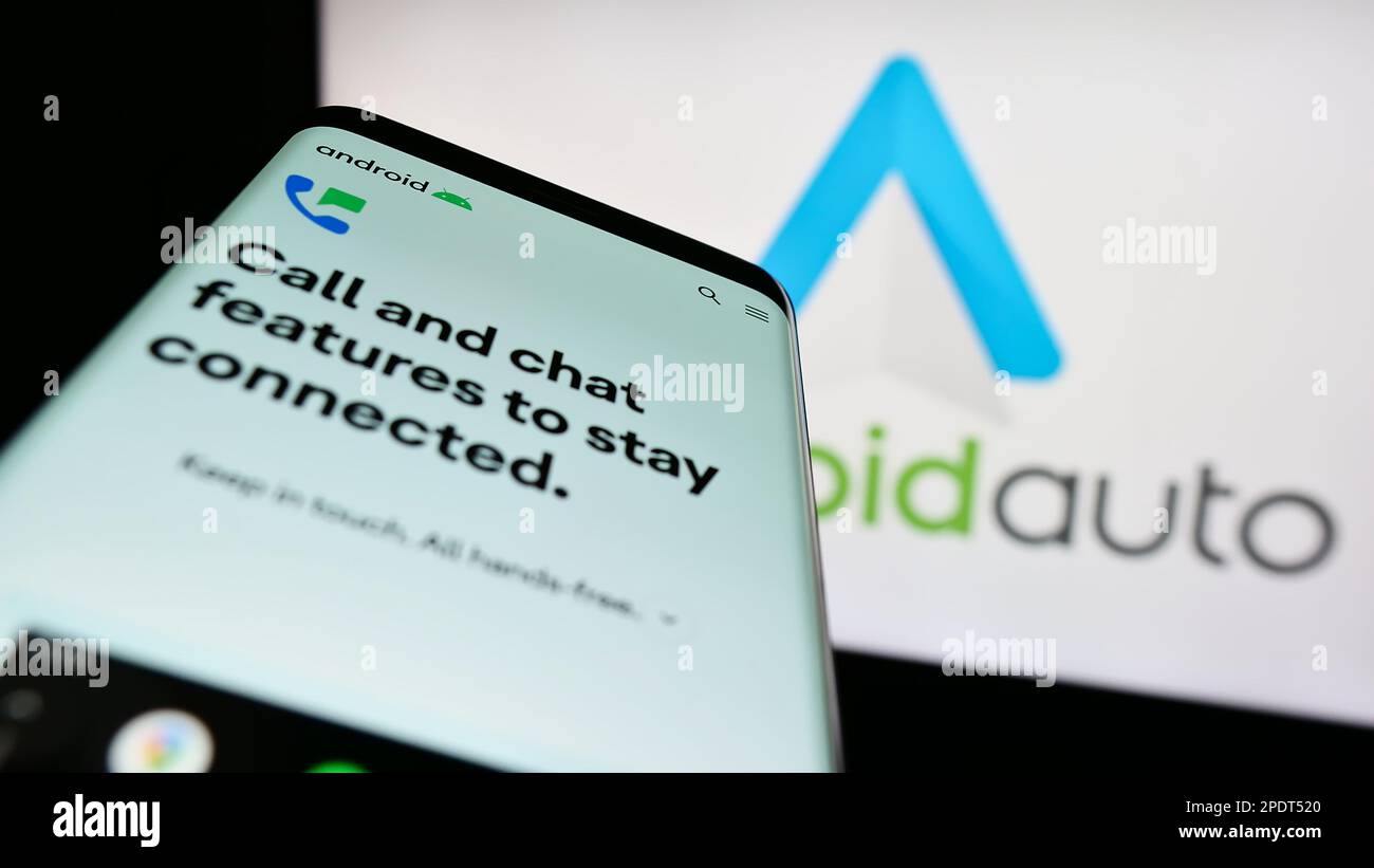 Mobile phone with web pageof mobile app Android Auto (Google) on screen ...