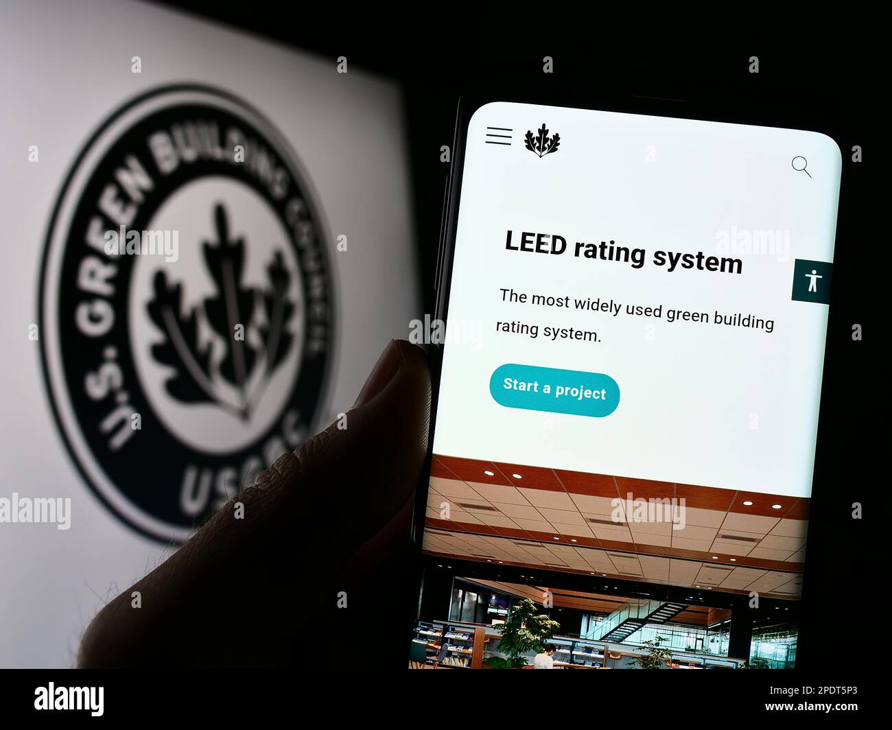Person holding cellphone with webpage of US Green Building Council ...