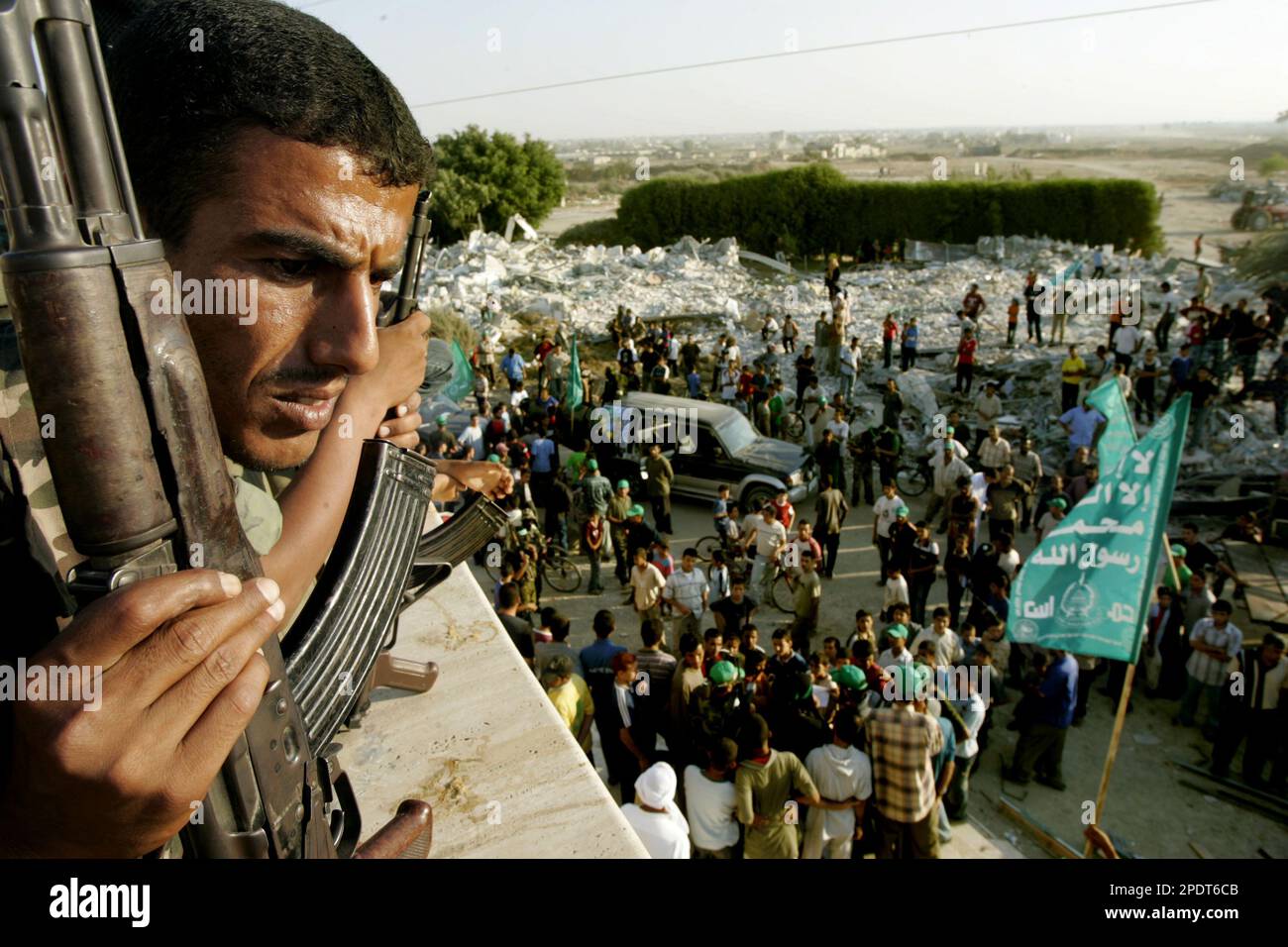 A Palestinian Hamas gunman looks at demonstrators around the synagog of ...