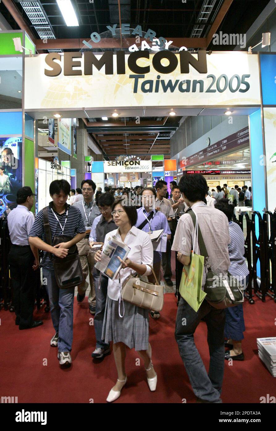 Visitors walk through exhibitors' booths on the first day of the ...