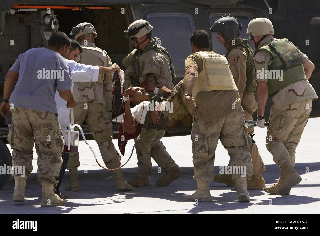 U.S. and Iraqi troops carry an injured Iraqi soldier toward a ...