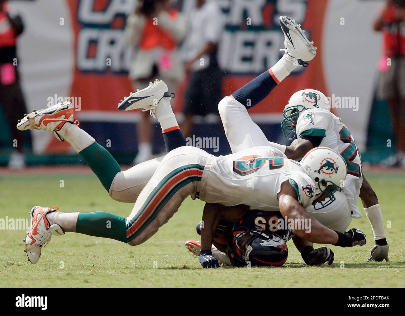 Denver Broncos' Ashley Lelie (85) is tackled by Miami Dolphins' Junior ...