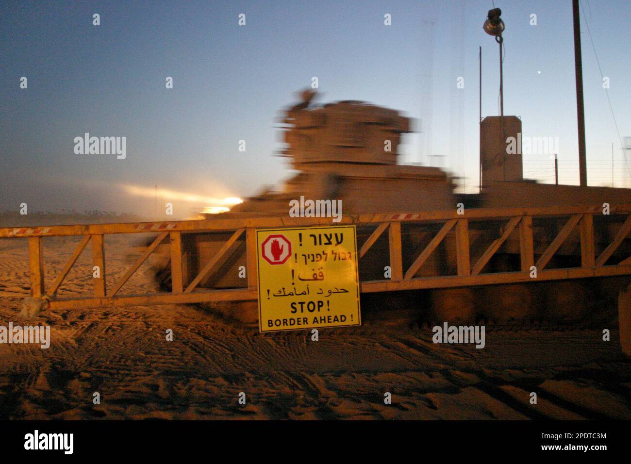 An Israeli army armored vehicle leaves the Gaza Strip through the Karni ...