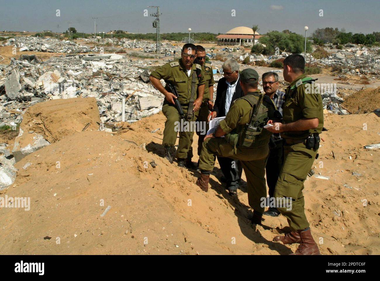 Israeli army officers confer with Palestinian officials as they stand ...