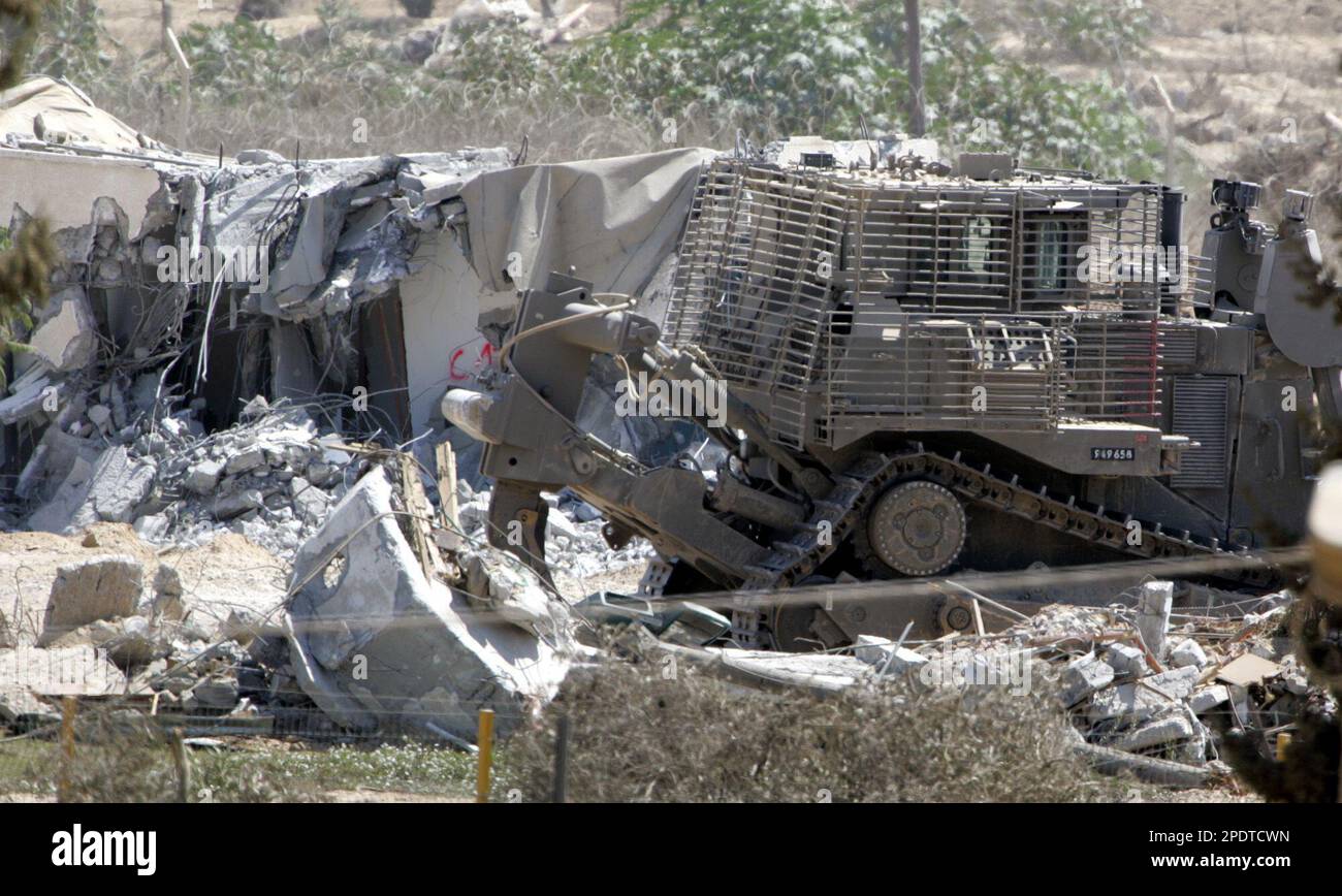 An Israeli bulldozer dismantles a building before the evacuation of the ...