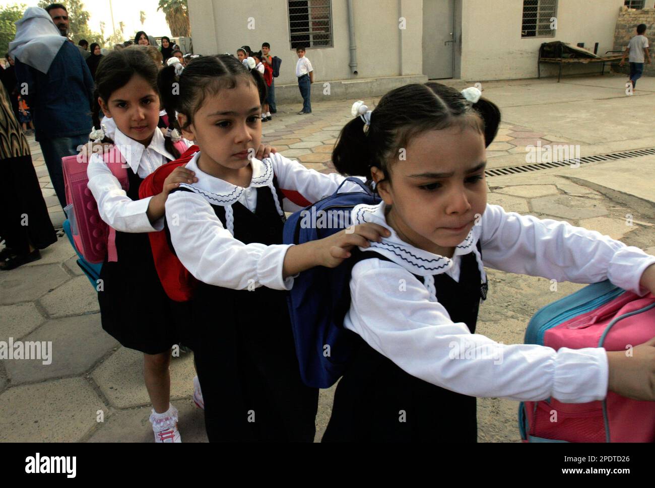 Iraqi school children enter their school, in Baghdad, Sunday, Sept. 11 ...