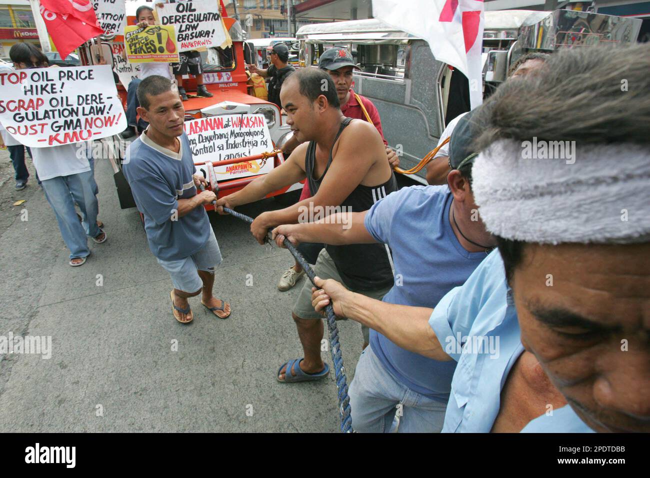 Militant drivers pull a Philippine passenger jeepney (modified jeep) in ...