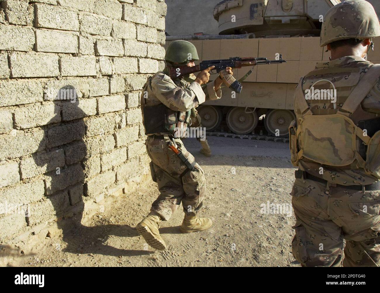 Iraqi Army soldiers from the Third Brigade pass a US Army Bradley ...