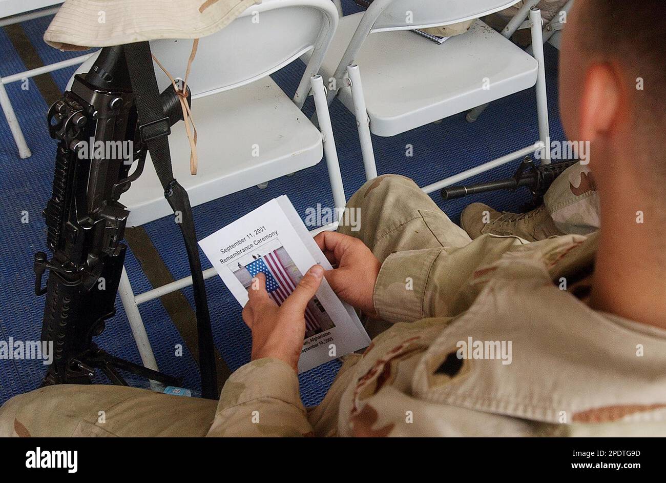 A U.S. soldier holds a pamphlet during a memorial ceremony to mark the ...